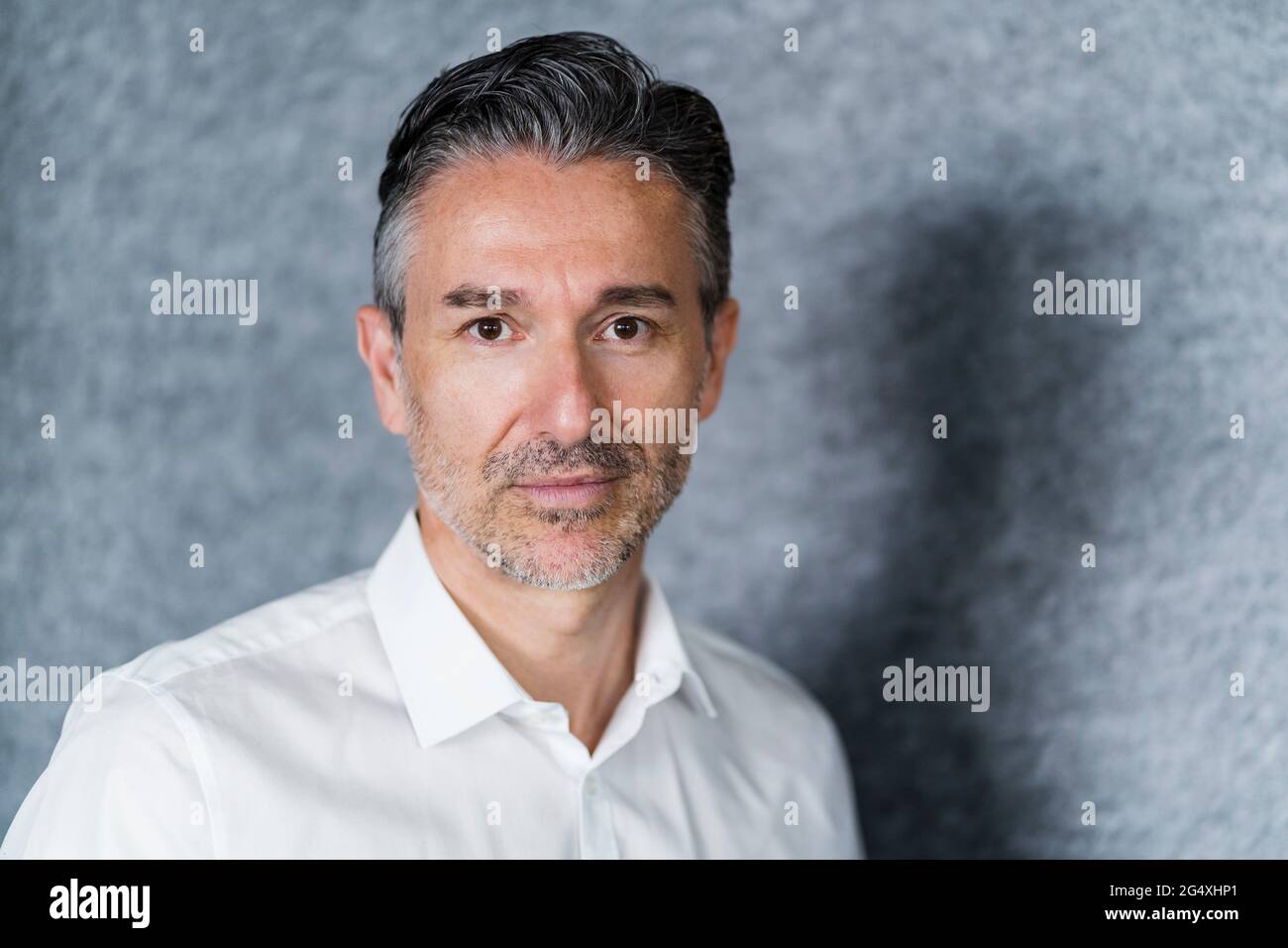Male professional standing in front of wall Stock Photo - Alamy
