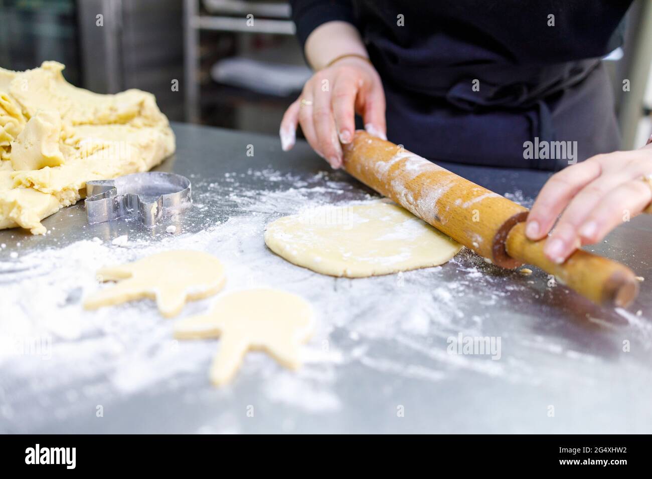 Female baker rolling dough in bakery Stock Photo - Alamy