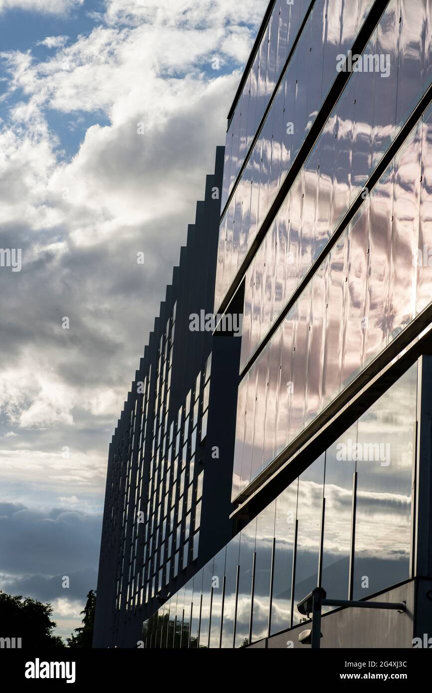 Spain, Madrid, Clouds reflecting in glass facade of Repsol Campus ...