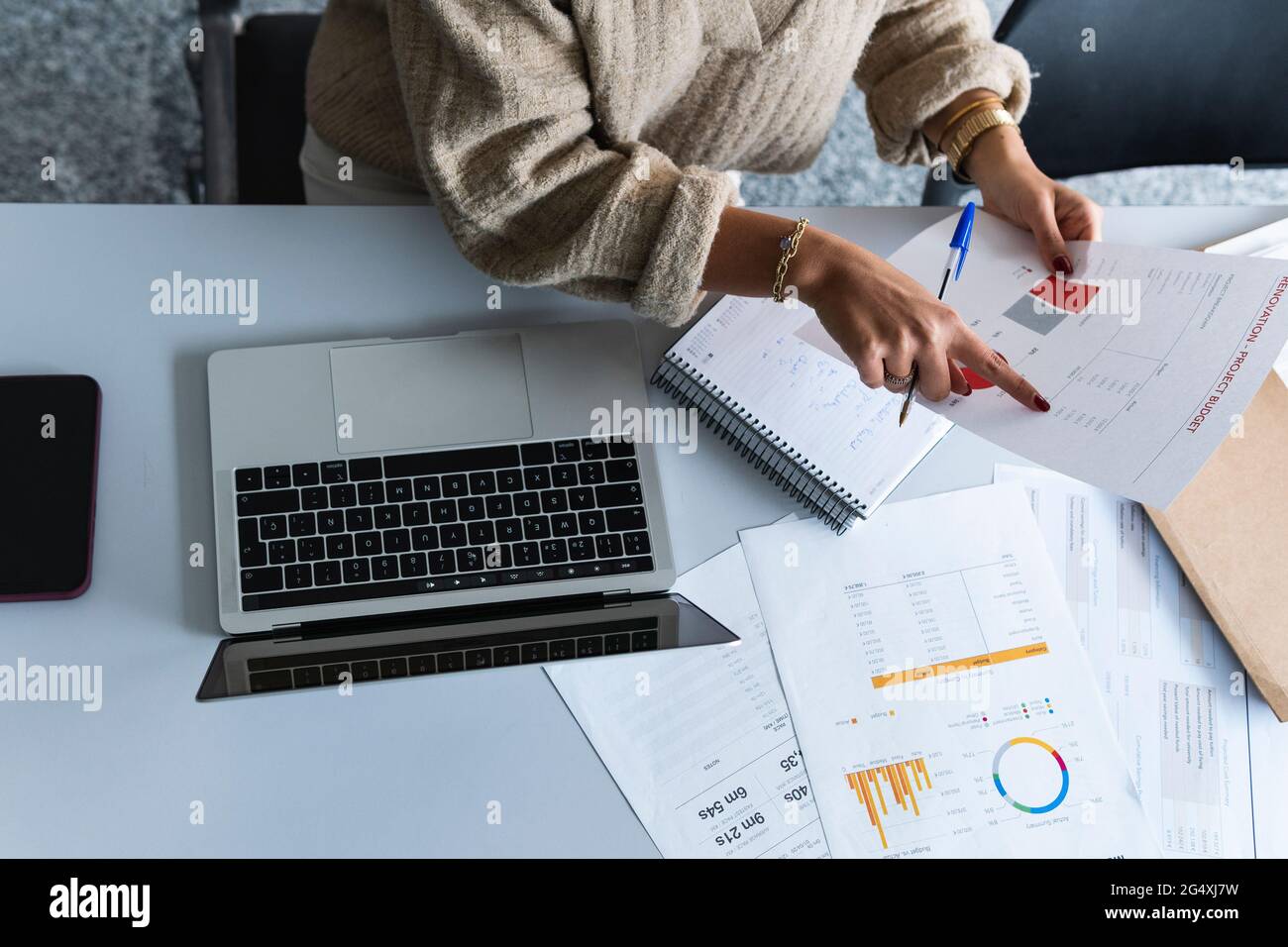 Female entrepreneur analyzing data while sitting in front of laptop at ...