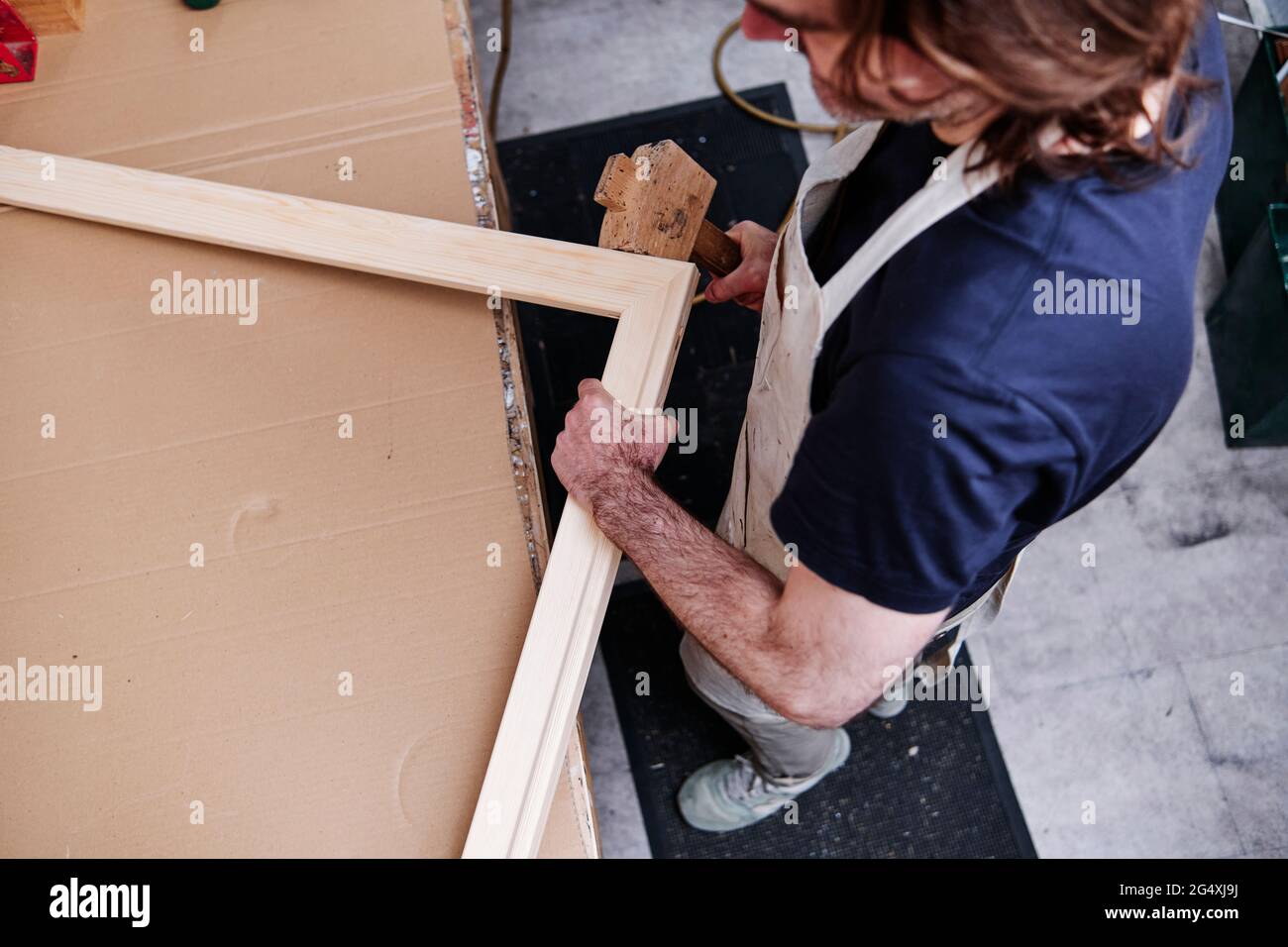 Craftsman using hammer while making wooden frame in workshop Stock ...