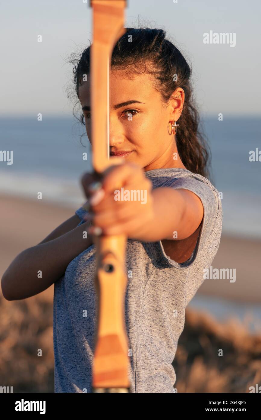 Young archeress aiming with bow and arrow Stock Photo - Alamy
