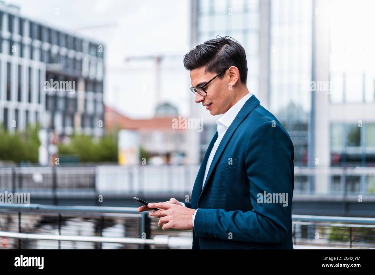 Male entrepreneur using smart phone by railing Stock Photo - Alamy