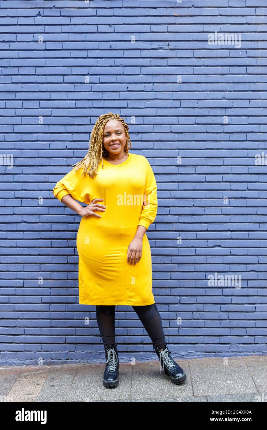 Confident plus size woman standing with hand on hip in front of ...