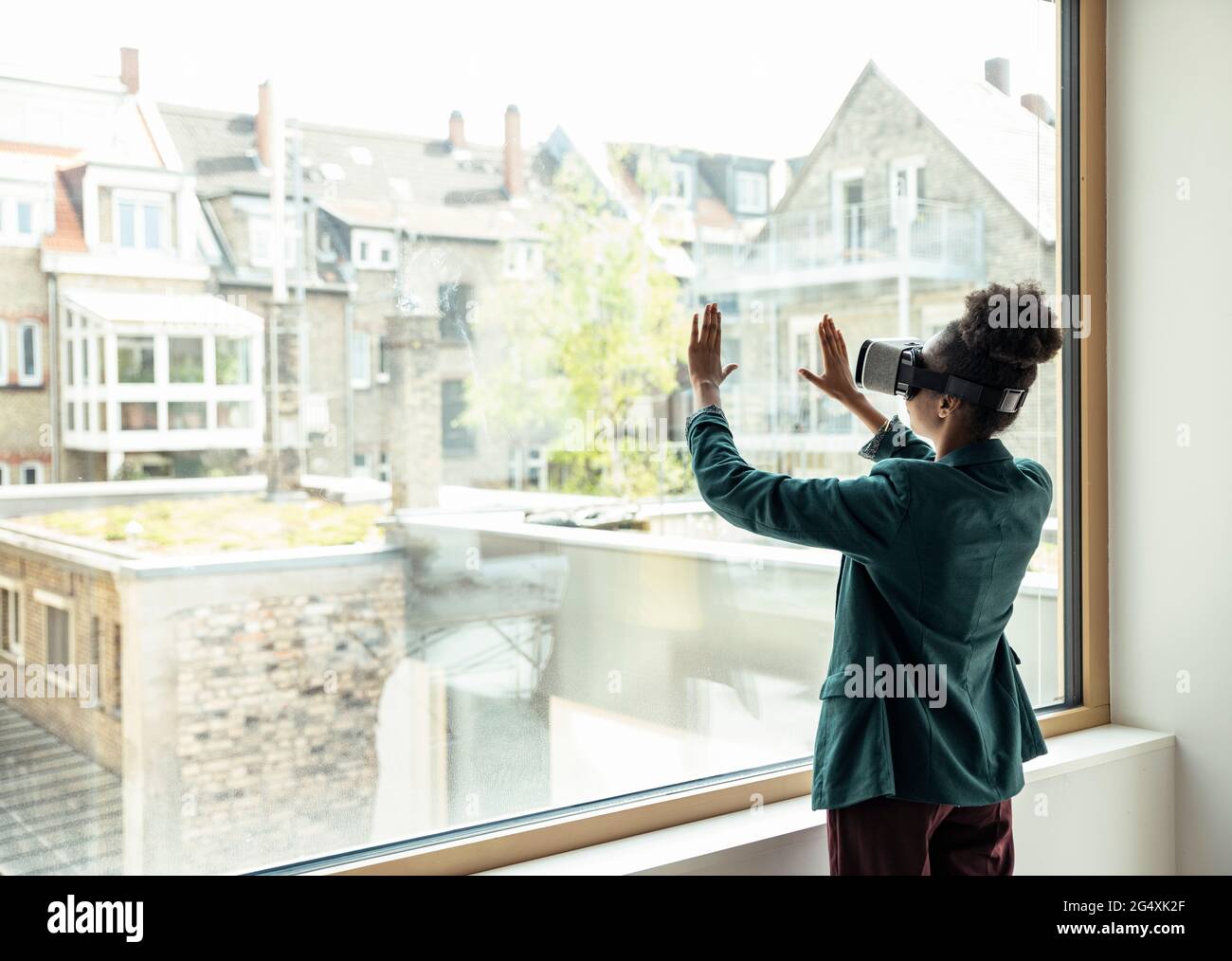 Female professional touching glass window while using virtual reality ...