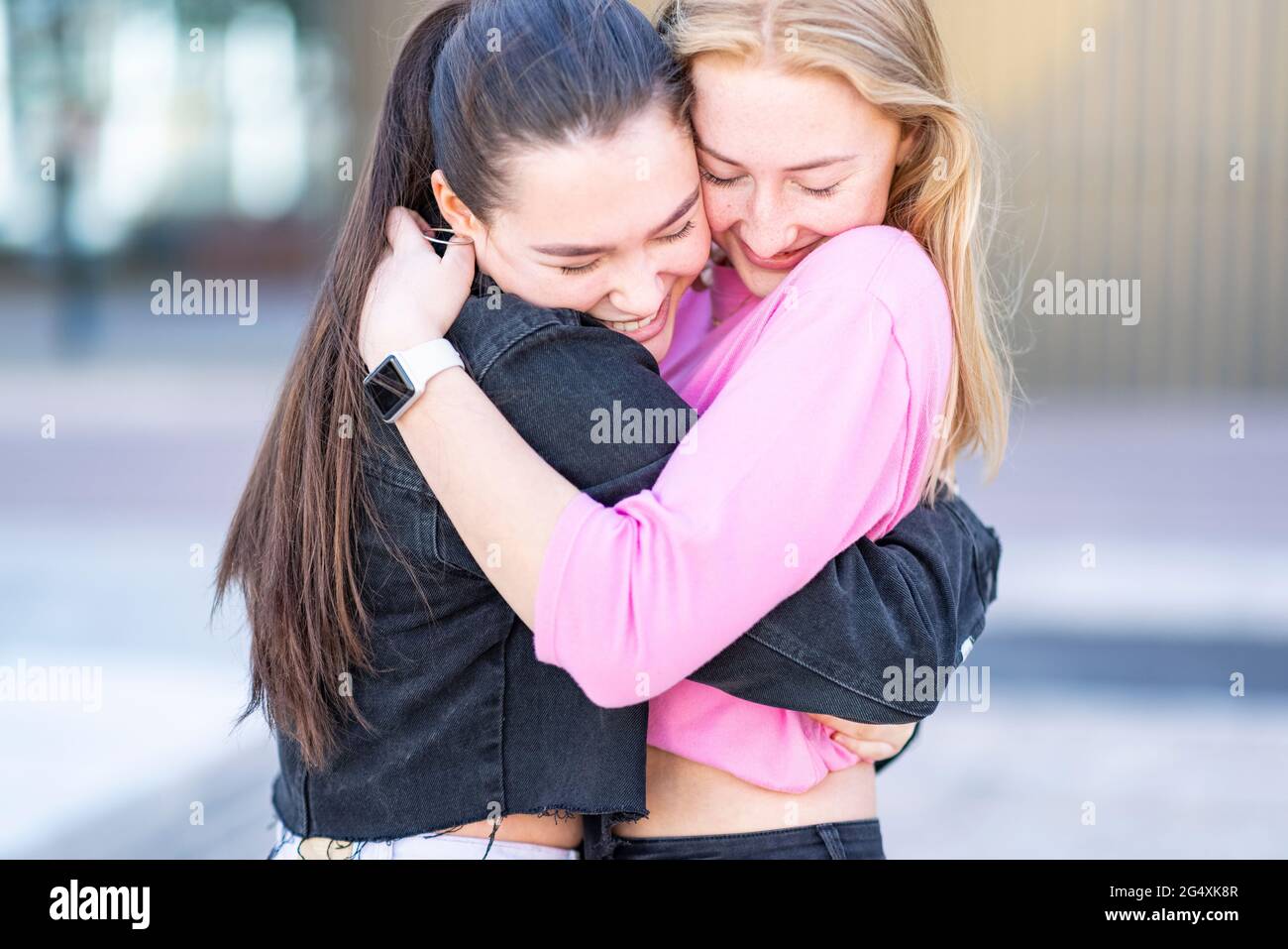 Two young happy female friends embracing hi-res stock photography and ...