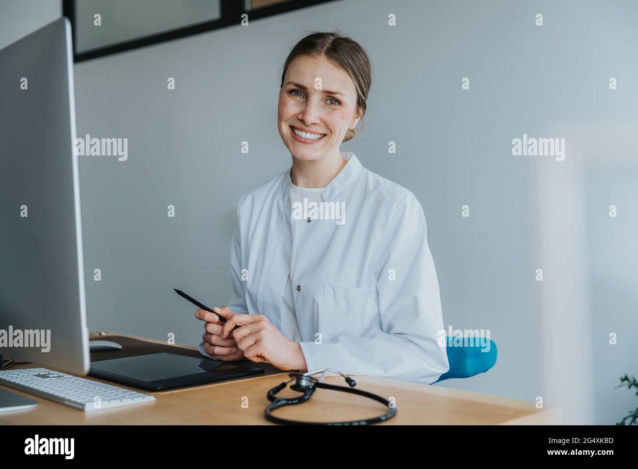 Doctor sitting at desk hi-res stock photography and images - Alamy