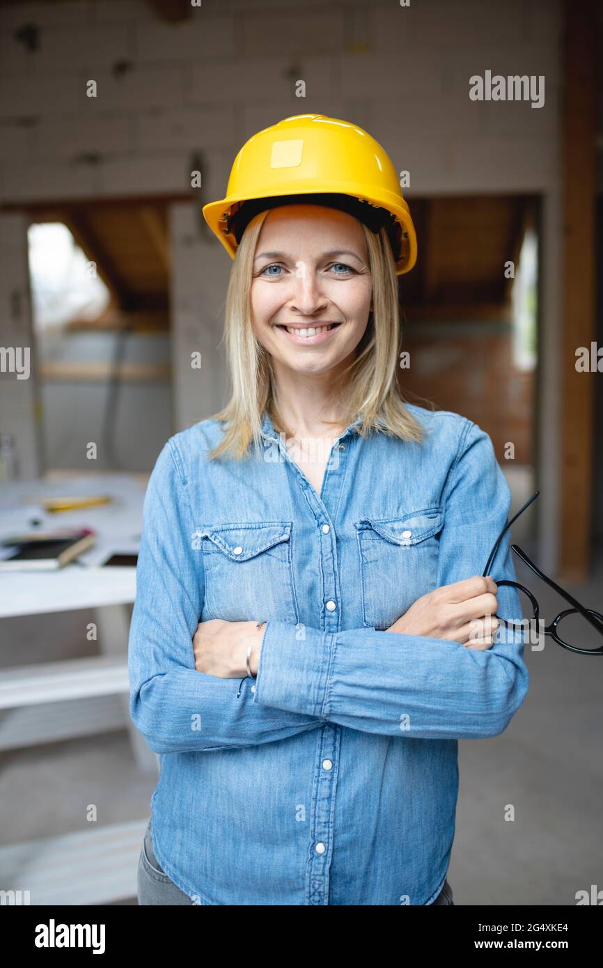 Confident female building contractor standing at construction site ...