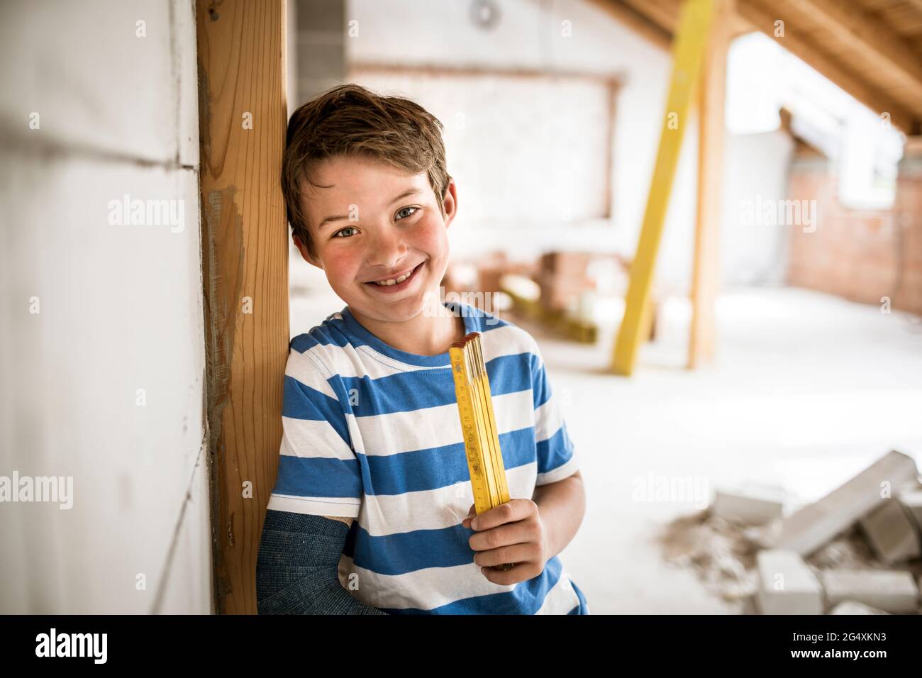Smiling boy holding tape measure during house renovation Stock Photo ...