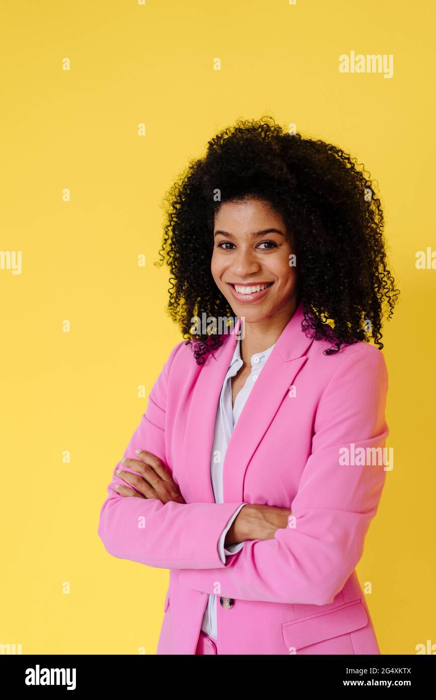 Smiling female professional with arms crossed standing in front of ...