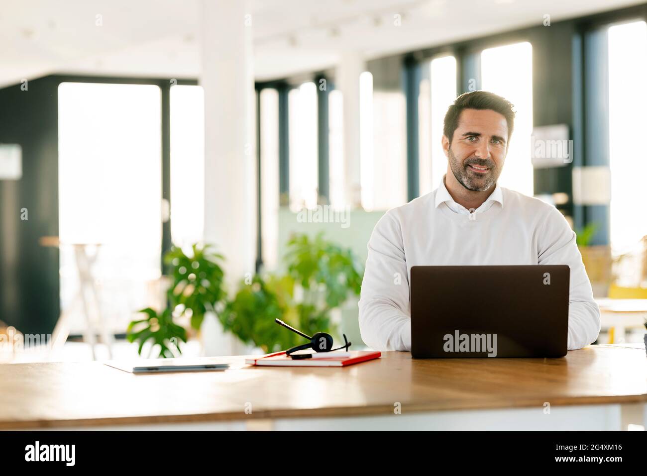 Male professional sitting in front of laptop at office cafeteria Stock ...
