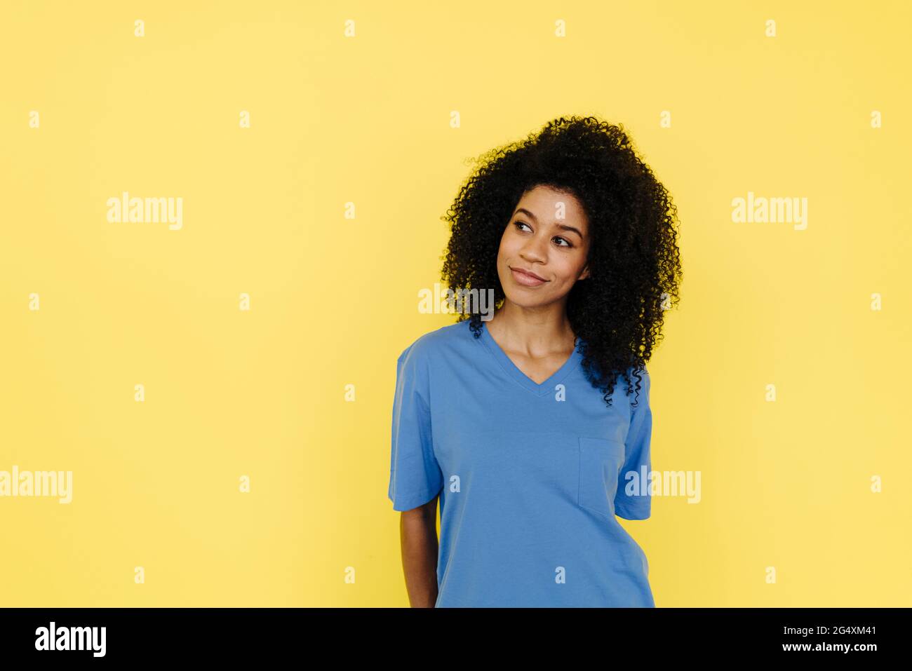 Afro woman contemplating against yellow background Stock Photo - Alamy