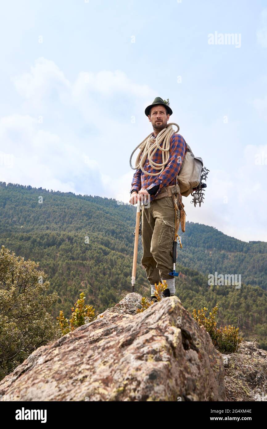 Male mountaineer with backpack and equipment standing on mountain Stock ...