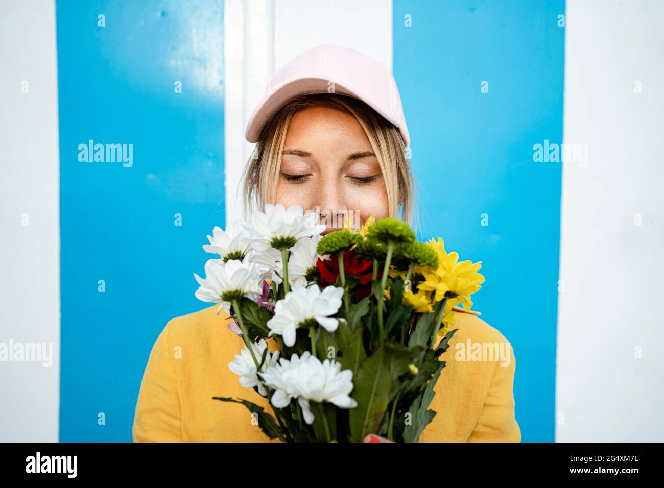 Beautiful woman with eyes closed smelling flower bouquet Stock Photo ...