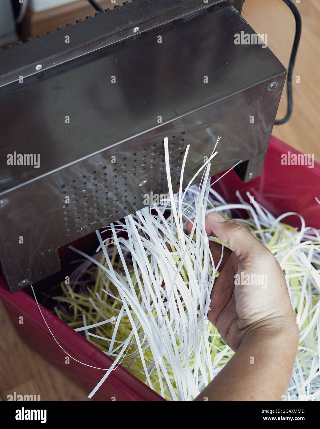 Shredding paper coming out from the machine with hand pulling Stock ...