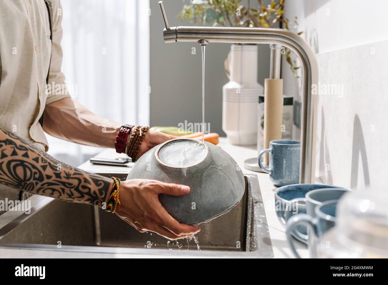 Man washing bowl in sink at home Stock Photo - Alamy