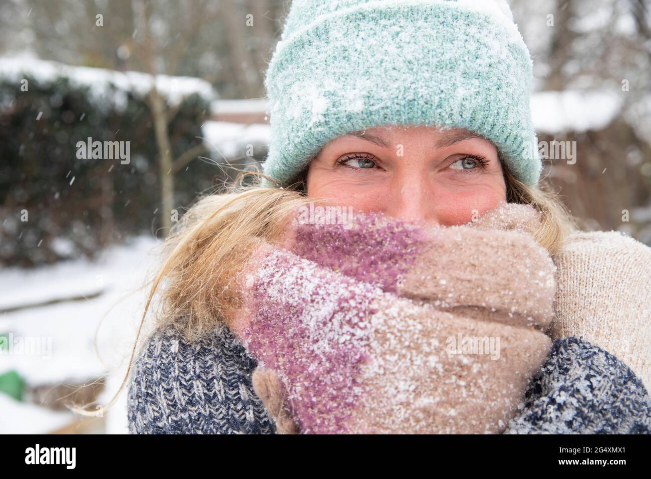 Mature woman covering face with scarf during winter looking away Stock ...
