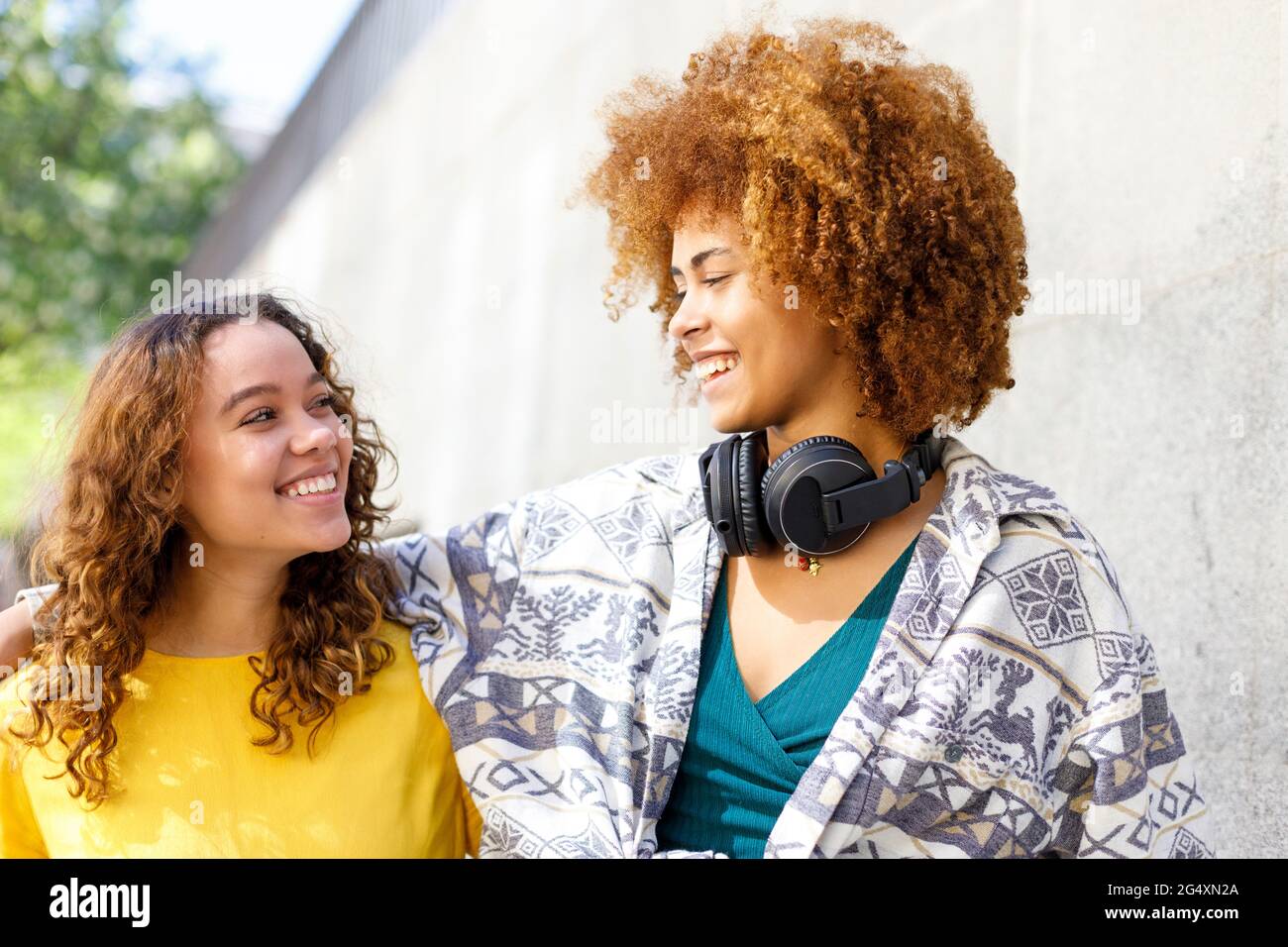 Happy female friends looking at each other Stock Photo - Alamy