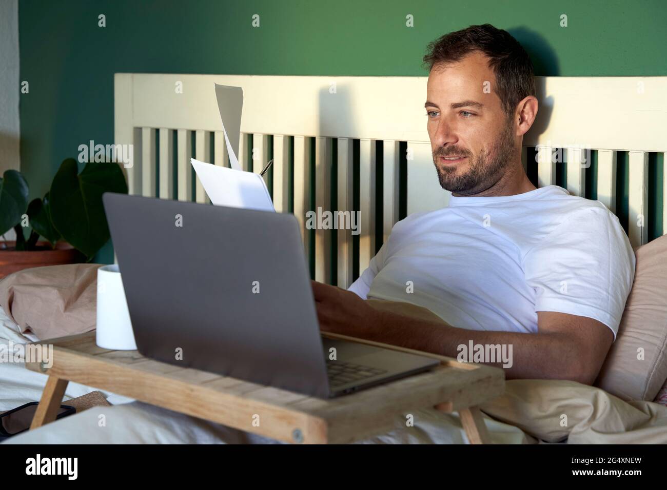 Mid adult man checking paper while working at home Stock Photo - Alamy