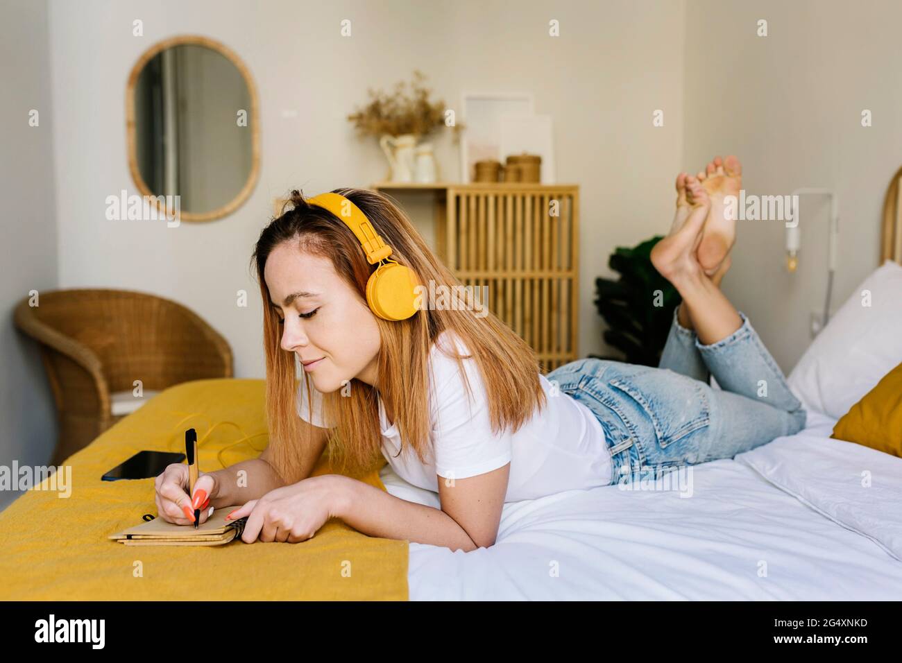 Woman lying on bed with pen and notepad hi-res stock photography and ...