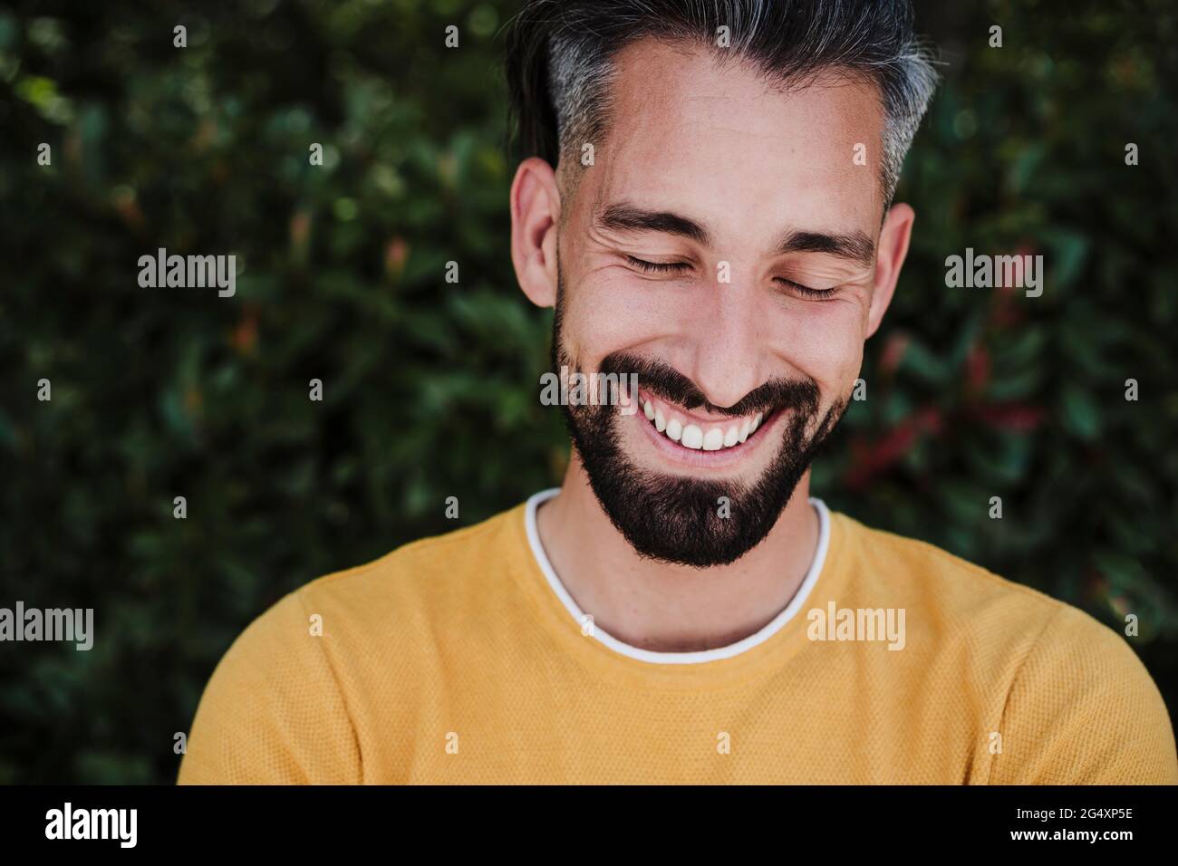 Mid adult man with eyes closed smiling at park Stock Photo - Alamy