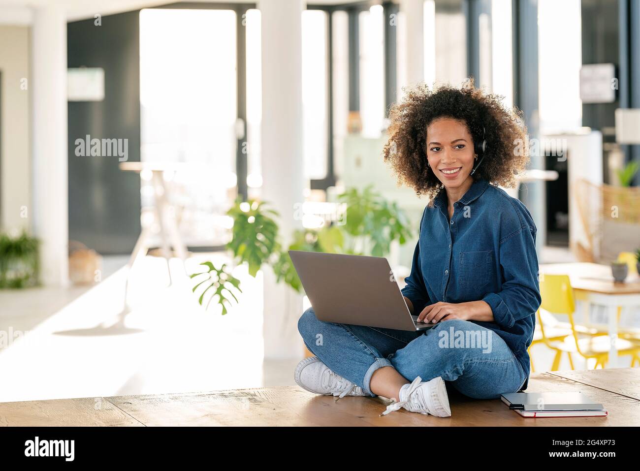 Female customer service representative with laptop smiling while ...