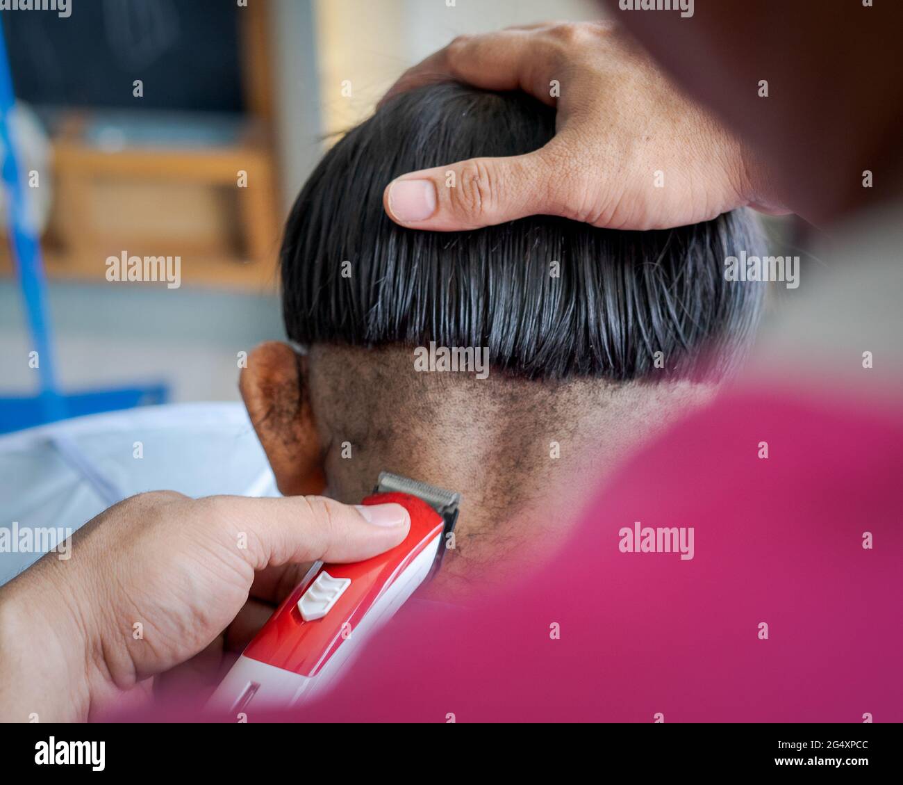 Asian child getting haircut at home from the father. Young boy save his ...