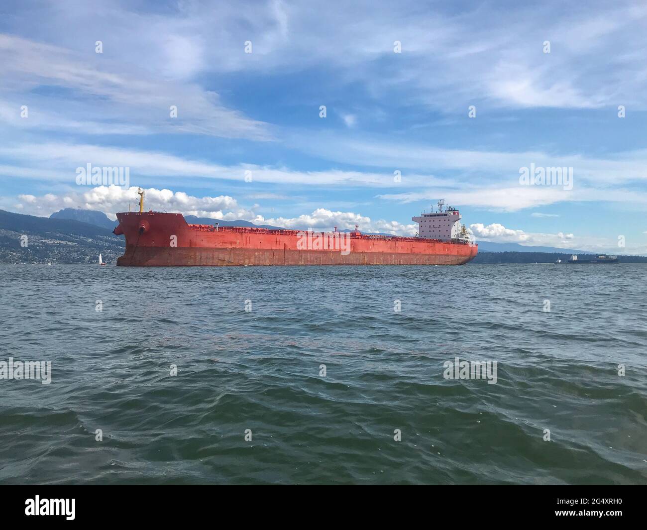 Freight ship cargo vessel at anchor in shore Stock Photo - Alamy