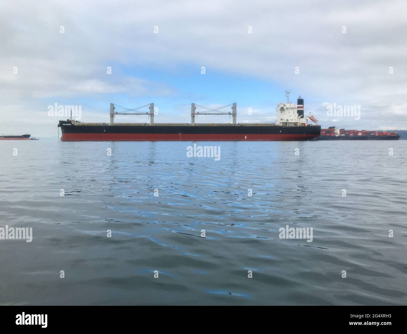 Freight ship cargo vessel at anchor in shore Stock Photo - Alamy