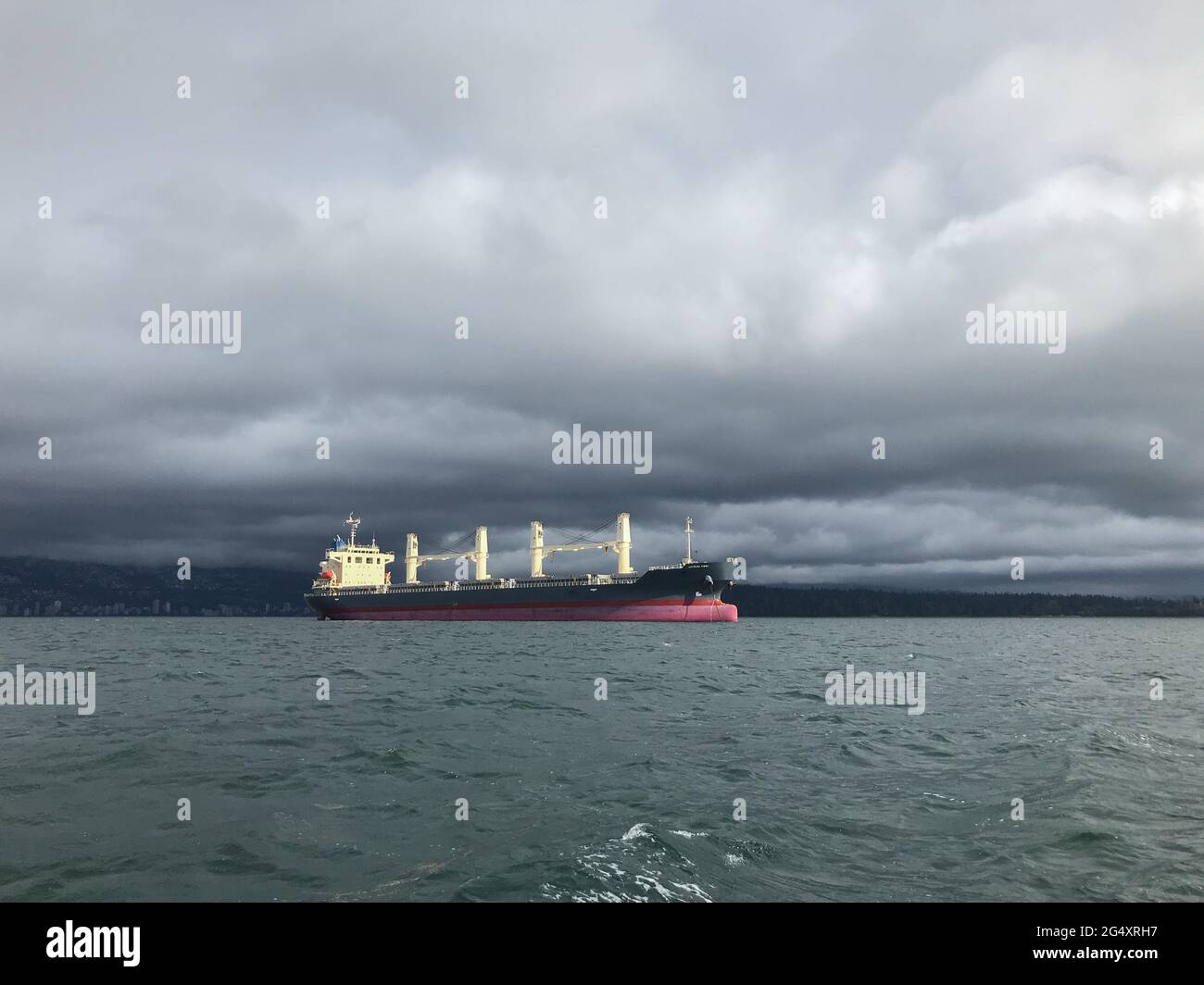 Freight ship cargo vessel at anchor in shore Stock Photo - Alamy