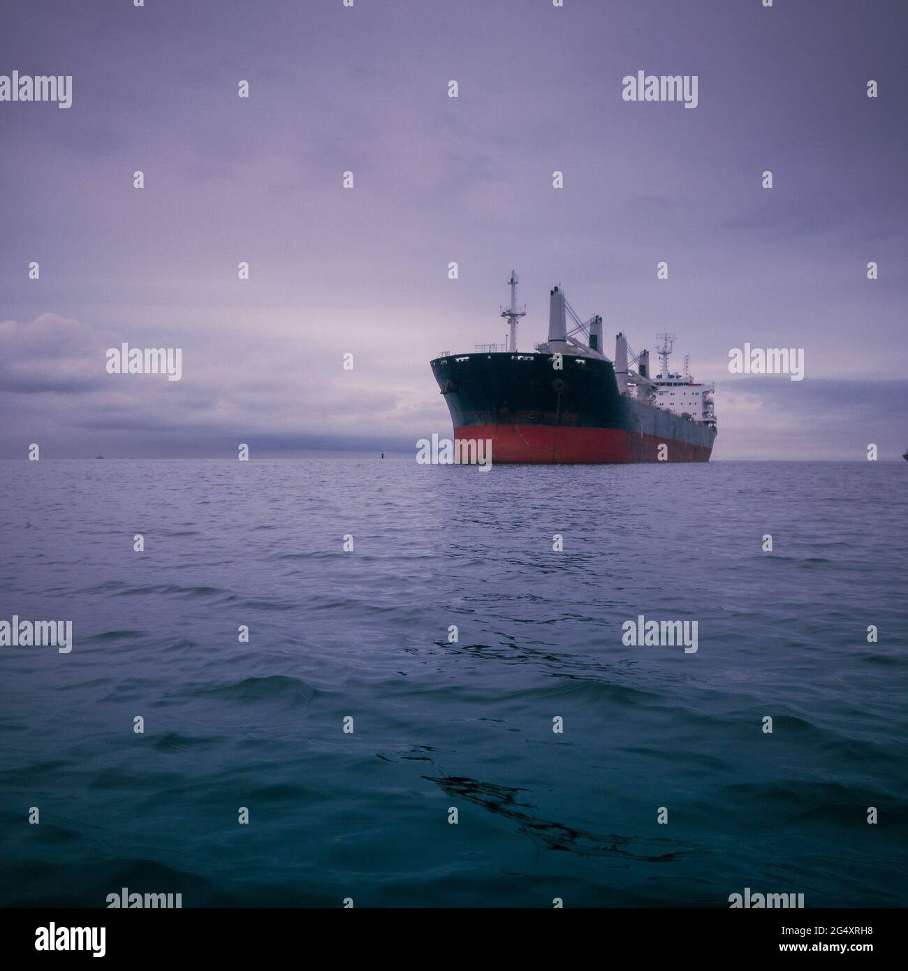 Freight ship cargo vessel at anchor in shore Stock Photo - Alamy