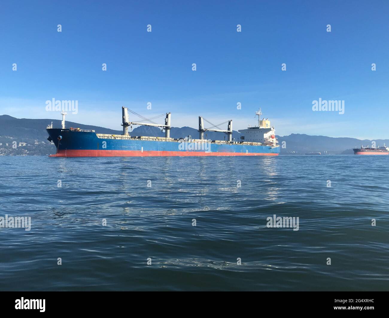 Freight ship cargo vessel at anchor in shore Stock Photo - Alamy