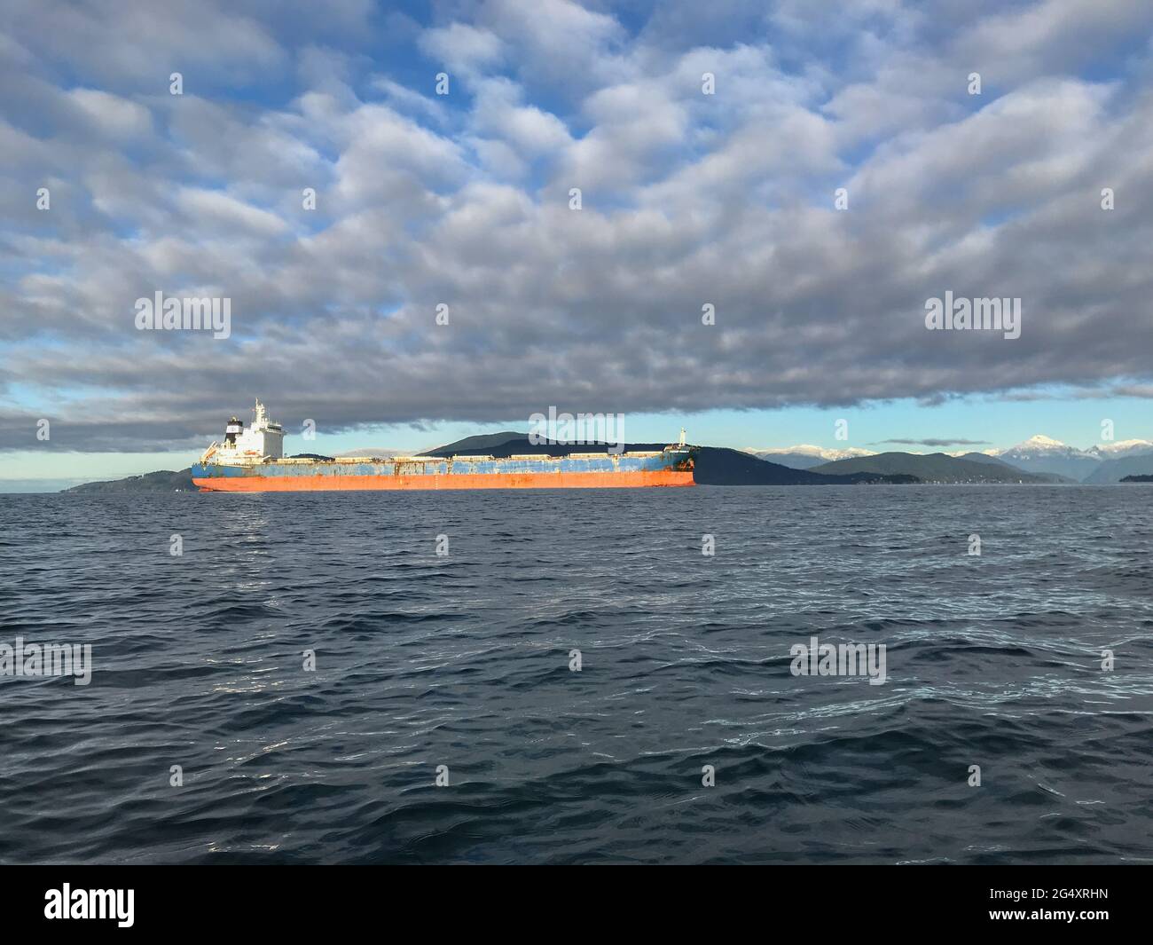 Freight ship cargo vessel at anchor in shore Stock Photo - Alamy