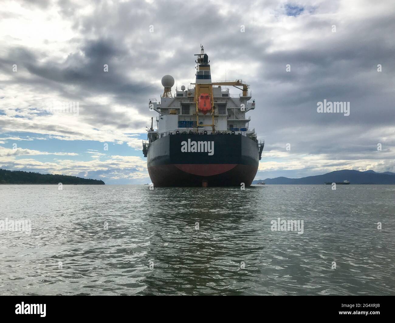 Stern view of cargo vessel freighter at anchor in bay Stock Photo - Alamy