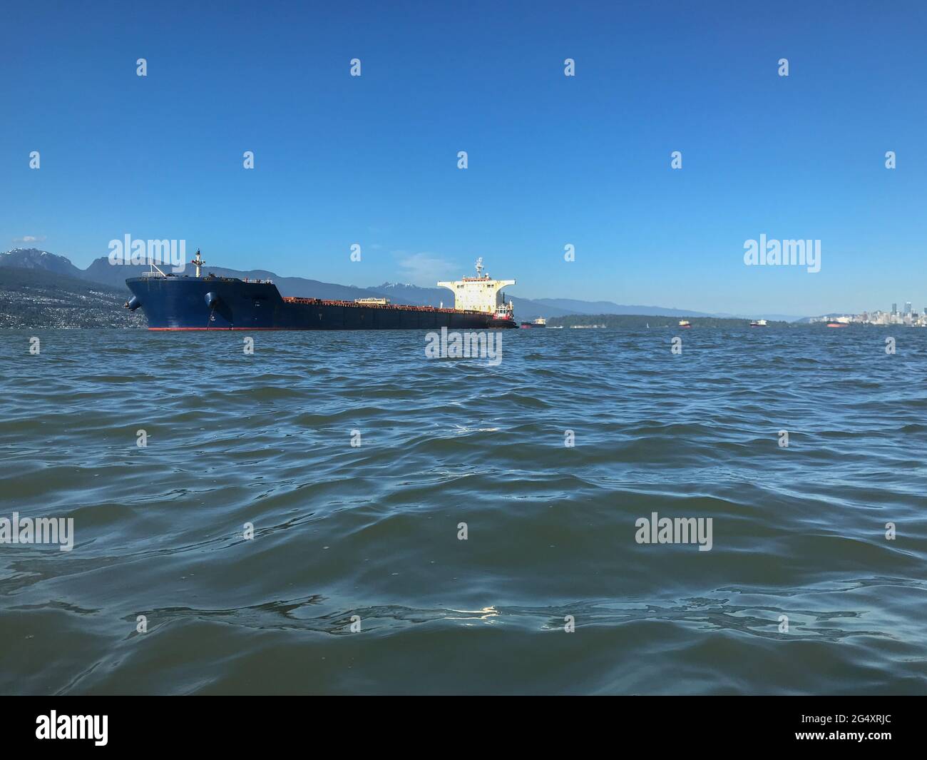 Freight ship cargo vessel at anchor in shore Stock Photo - Alamy