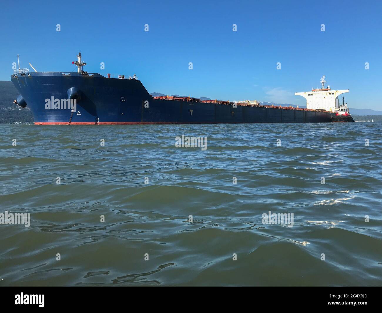 Freight ship cargo vessel at anchor in shore Stock Photo - Alamy