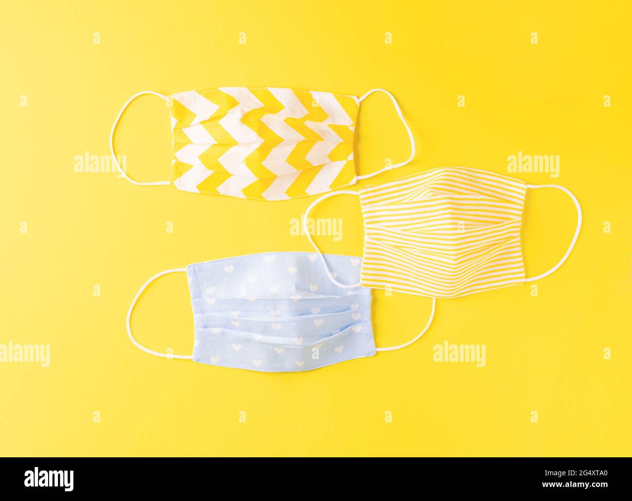 Eco-friendly reusable cloth protective mask yellow background. Homemade ...