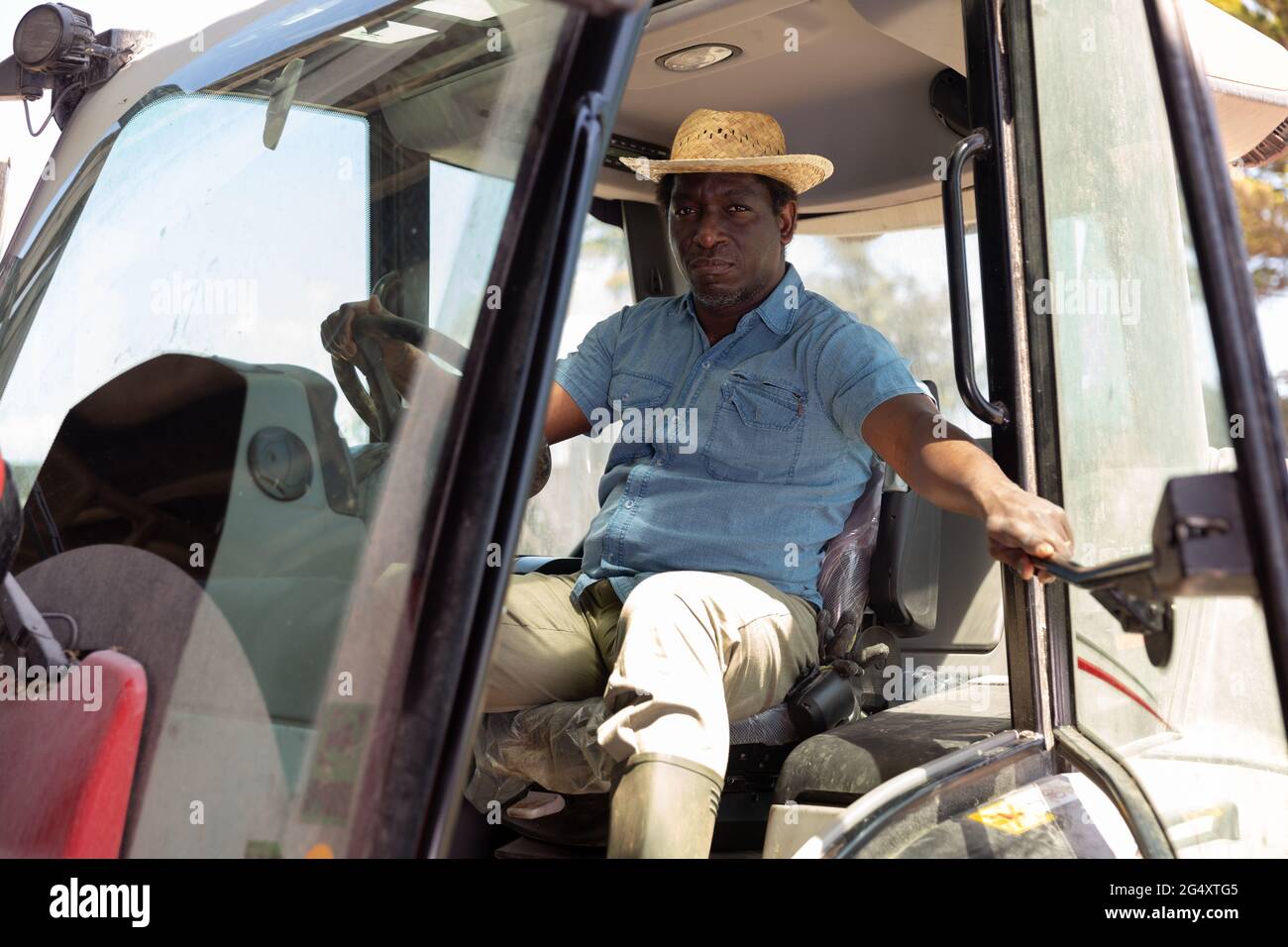 Man driving farm tractor during spring works on cowshed Stock Photo - Alamy