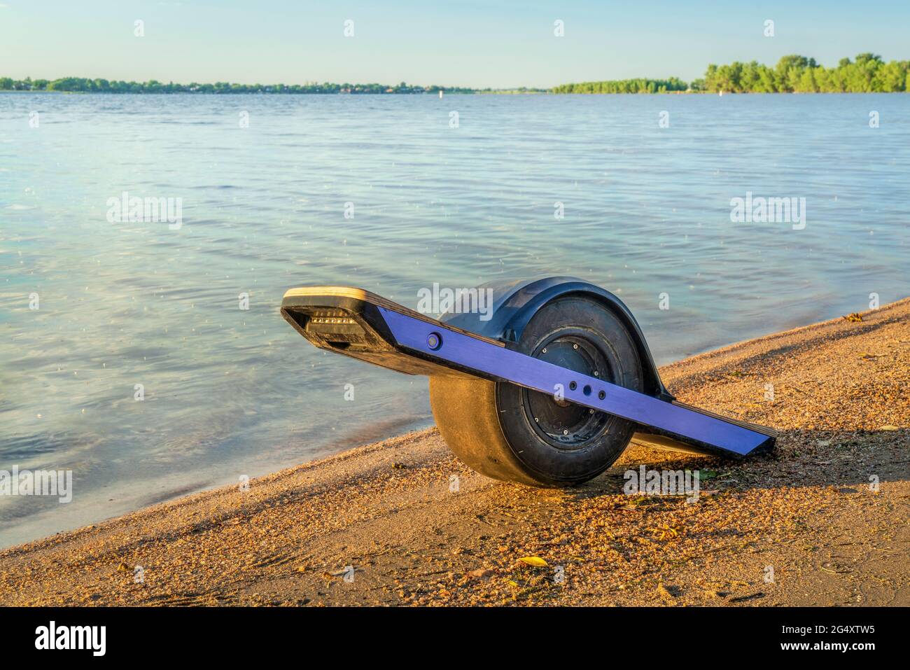 One-wheeled electric skateboard (personal transporter) on a lake shore ...