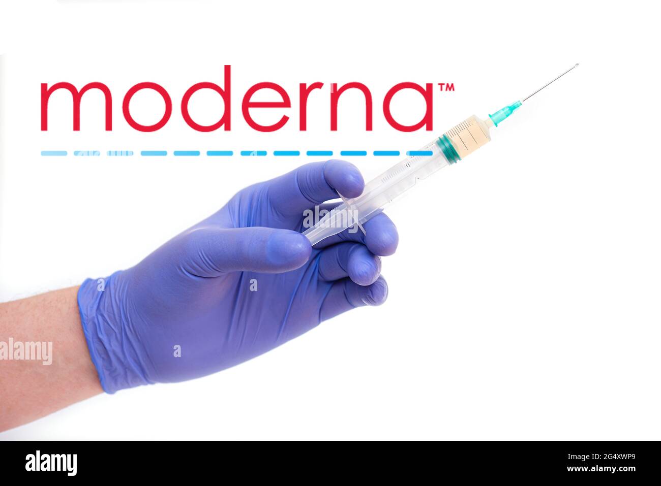 BERLIN - JUNE 23: MODERNA logotype and a doctor holding syringe with ...