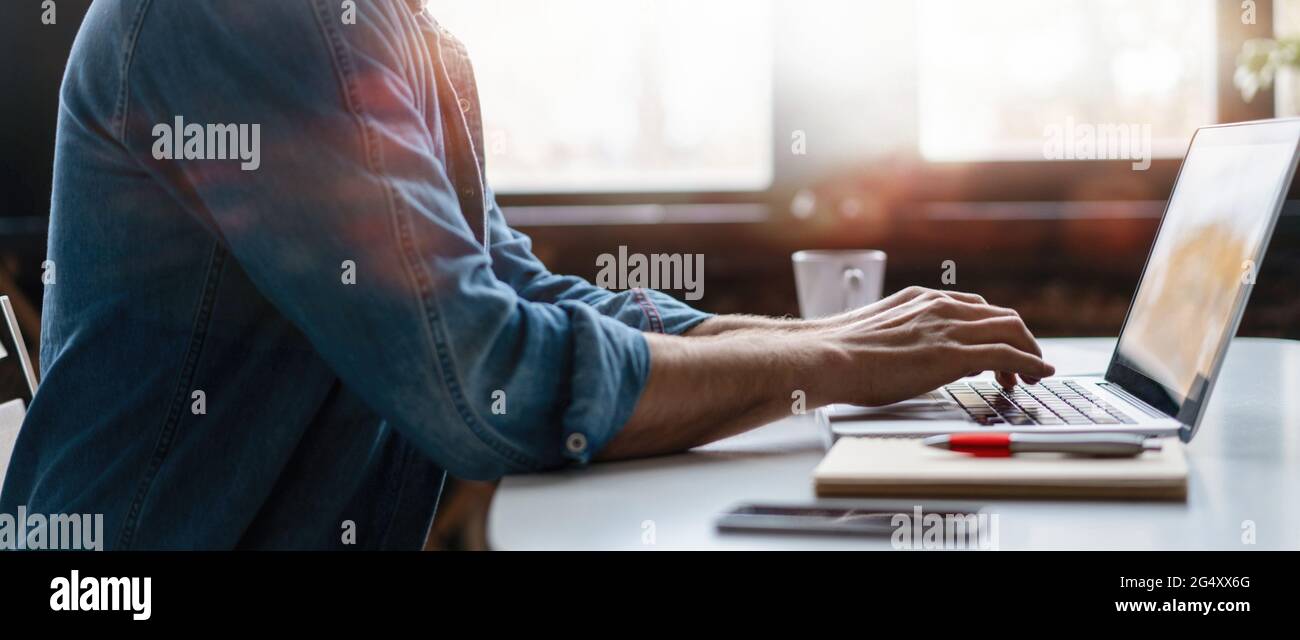 Businessman hands typing on laptop keyboard in morning light (computer ...