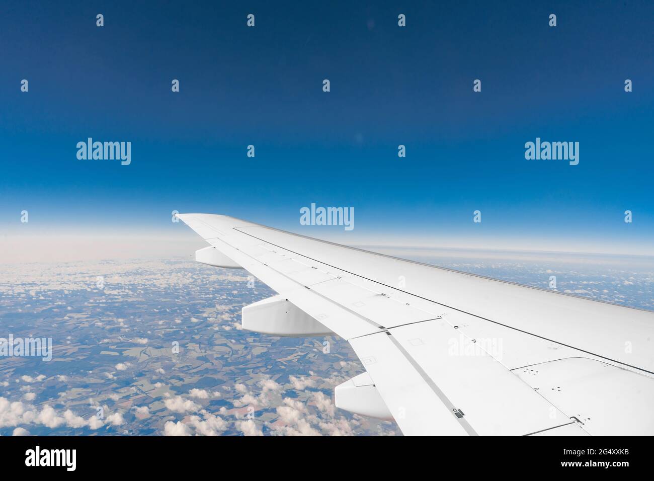 Wing of passsanger plane above the land, view from inside Stock Photo ...