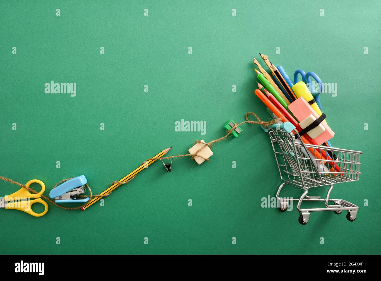 Shopping concept with shopping cart with school supplies on top and ...