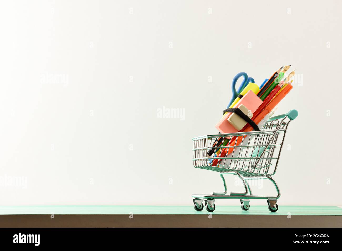 School supplies shopping concept with mini shopping cart full of school ...