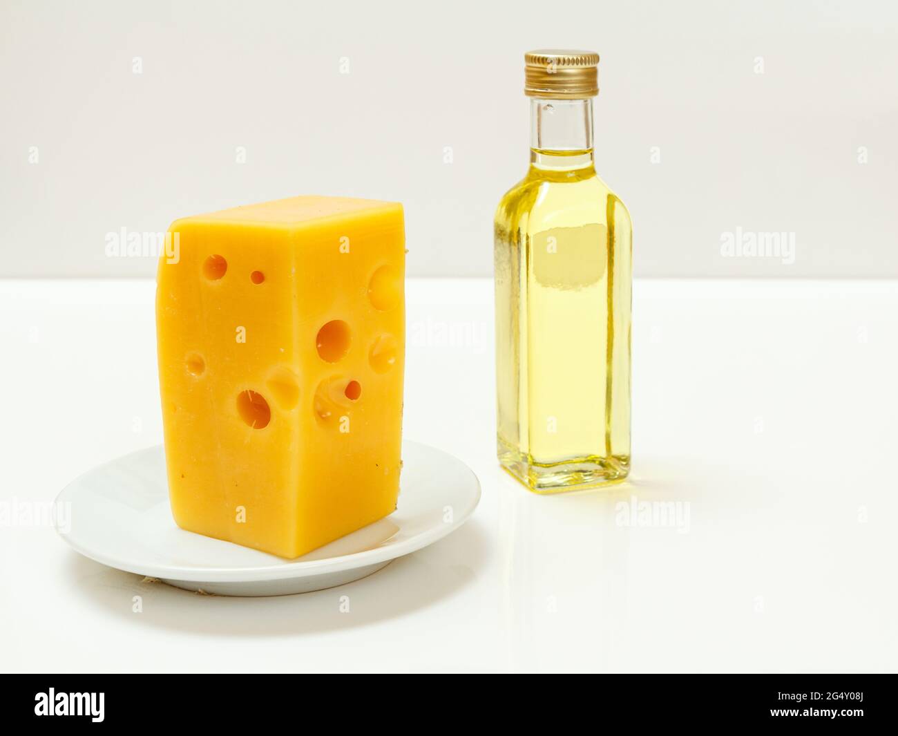Cheese hit fitness on plate and sunflower oil on white background Stock ...