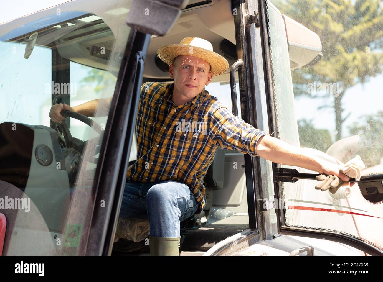Portrait of focused male worker driving tractor Stock Photo - Alamy