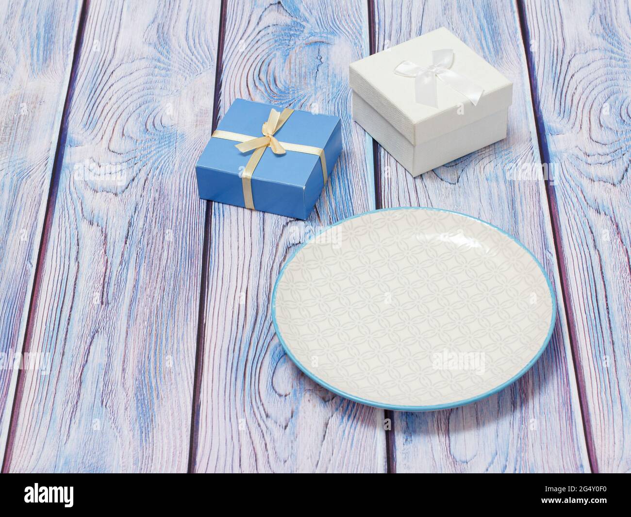 Porcelain plate and gift boxes on wooden background Stock Photo - Alamy
