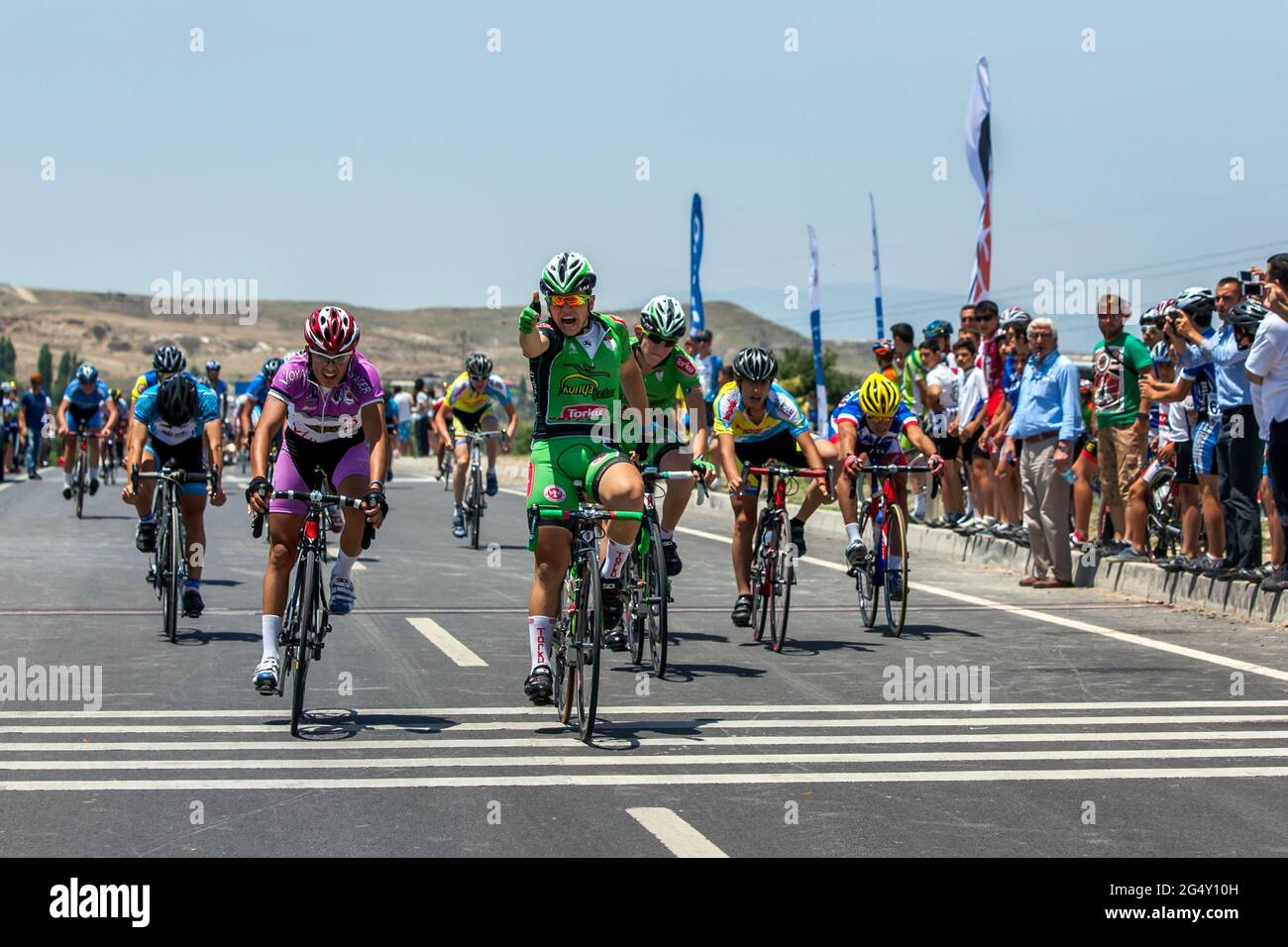 Junior cyclists cross the finish line during a road race at the Turkish ...