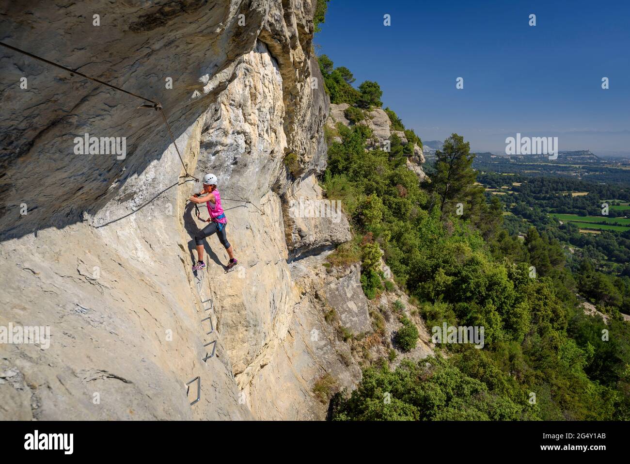 Climbers ascending the Baumes Corcades via ferrata in Centelles (Osona ...