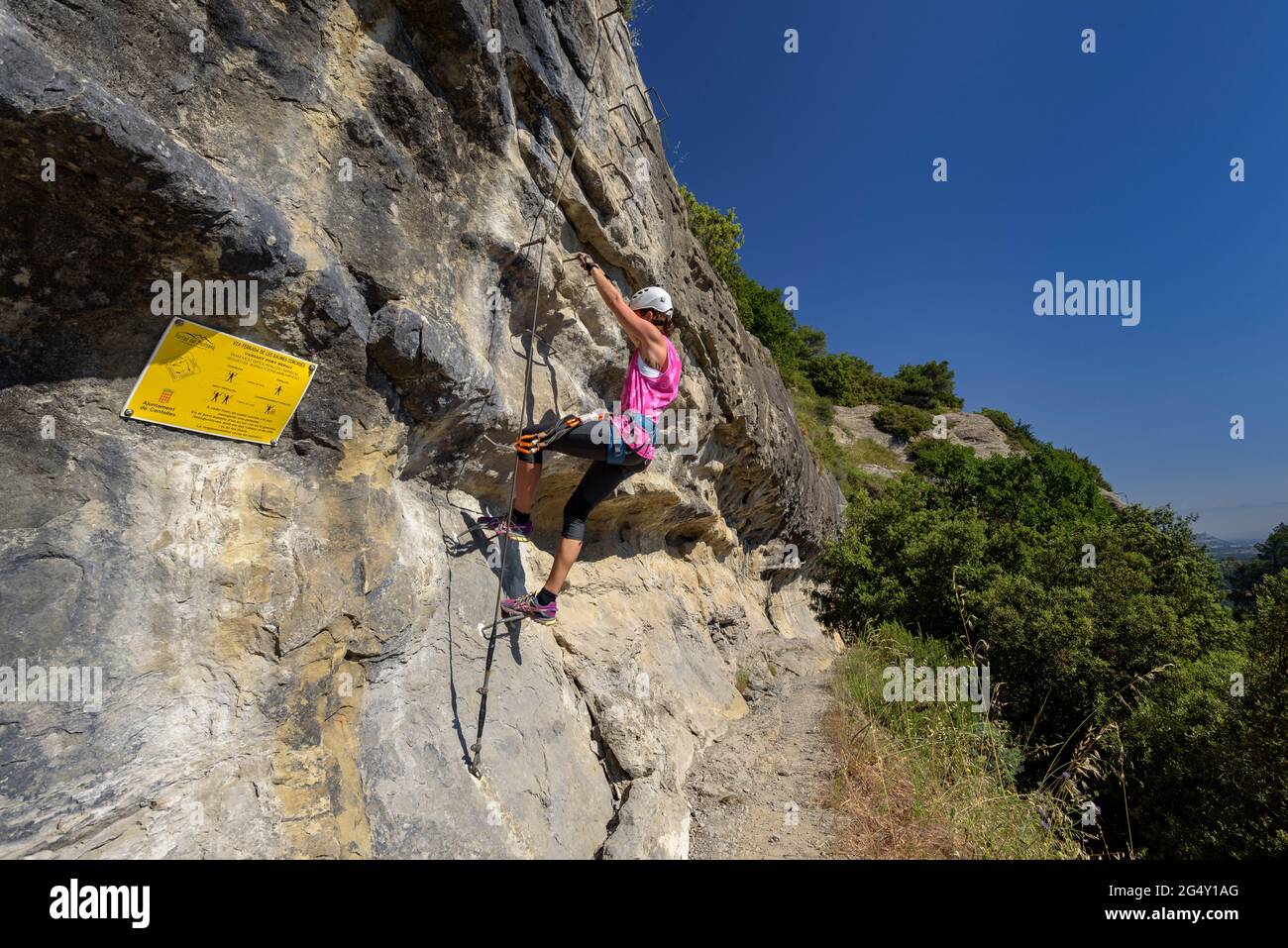 Climbers ascending the Baumes Corcades via ferrata in Centelles (Osona ...